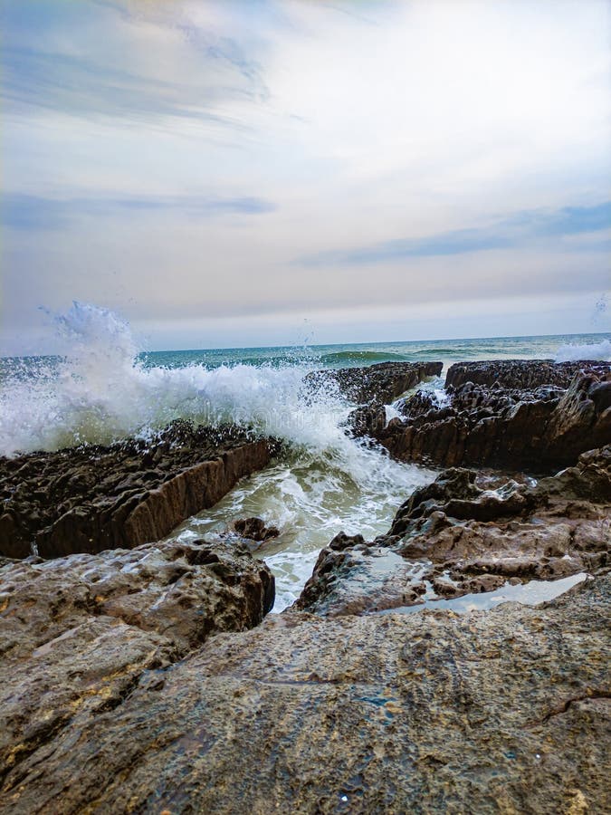 Splashing surf on rocks. stock photo. Image of sand - 250447018