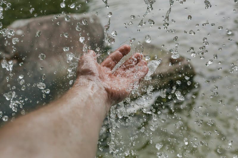 Splashing Water Falling on a Man`s Hand from a Waterfall Stock Image ...