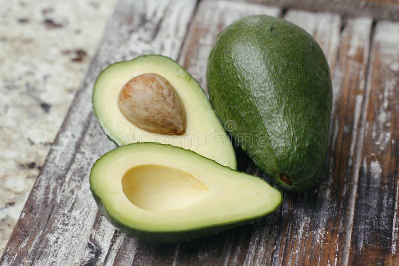 Split Fresh Raw Avocado with and without Pit. on Wooden Table. Stock ...