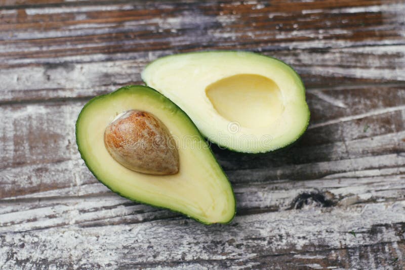 Split Fresh Raw Avocado with and without Pit. on Wooden Table. Stock ...