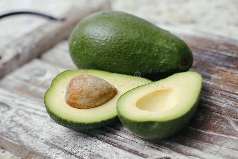 Split Fresh Raw Avocado with and without Pit. on Wooden Table. Stock ...