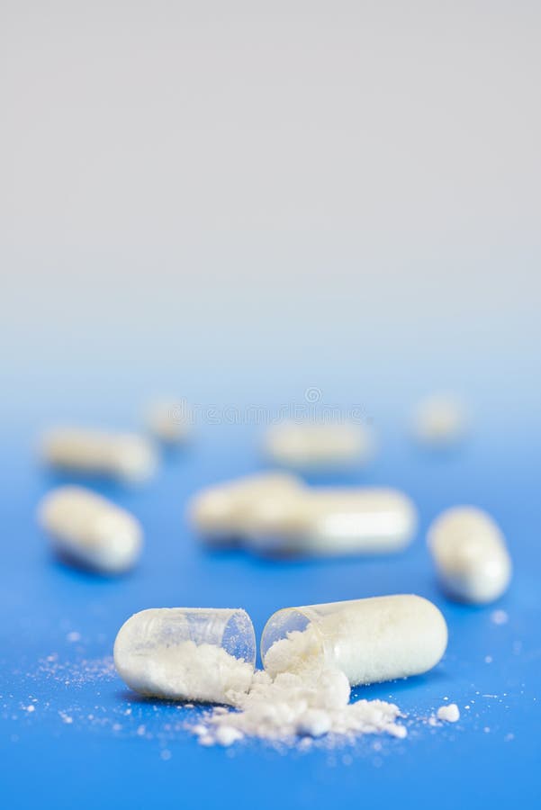 Split-open Transparent Capsule with White Powder on Blue Gradient ...