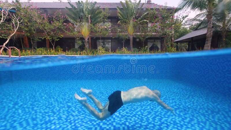 Split Underwater Shot of a Man Swimming in the Pool on a Summer Day in ...
