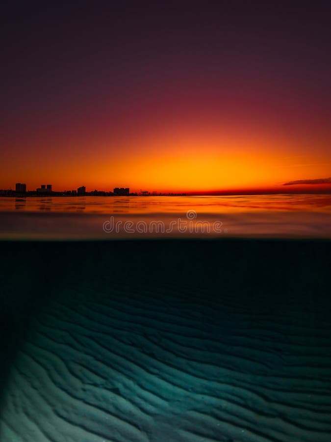 Split View with Colorful Sunset and Underwater Sandy Sea Bottom Stock ...