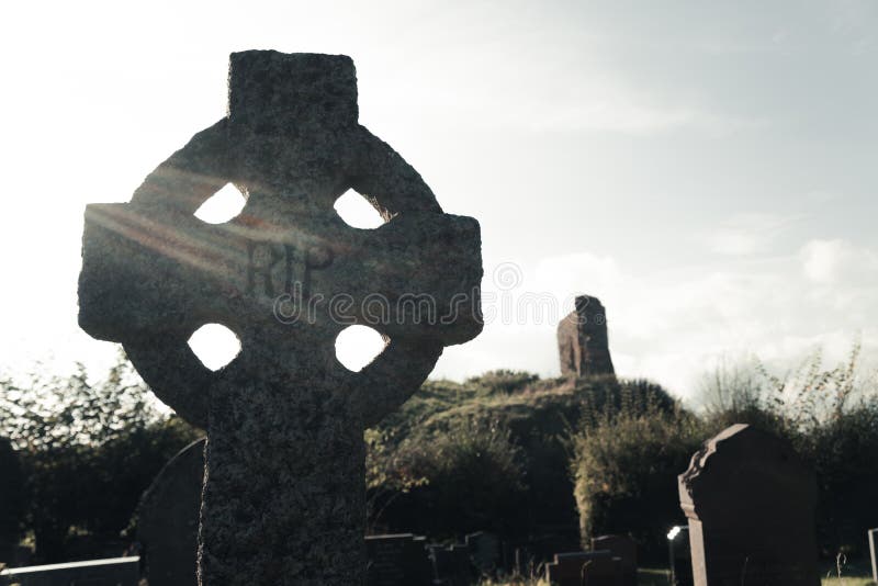 A Spooky Concept of a Cross in a Graveyard. Backlighted by the Setting ...