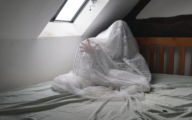 A Spooky, Ghostly Figure Sitting on a Bed, with a Hand Reaching Out in ...