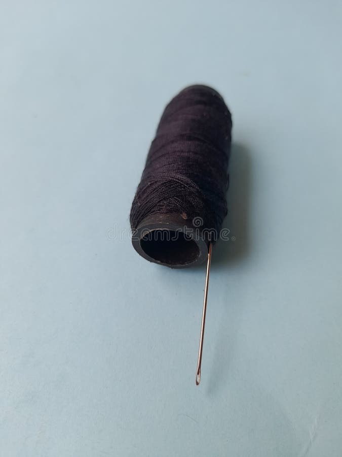 Skein of Black Thread and Needle on a Blue Background Stock Photo ...