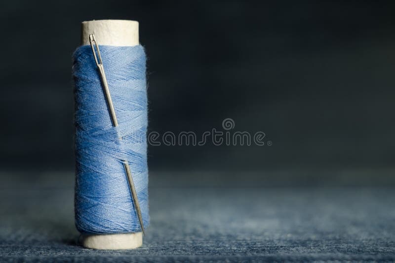 Spool of Blue Sewing Thread with Needle on Old Denim Background Stock ...