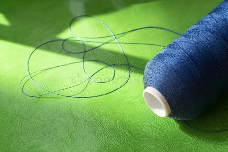 A Spool of Blue Thread on a Green Leather. Sewing Thread. Shoe Industry ...
