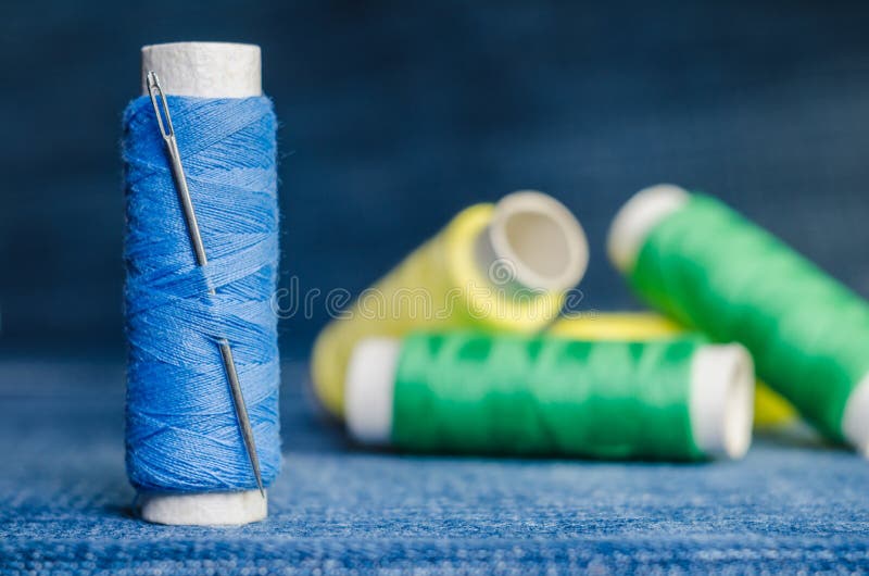 Spool of Green and Yellow Thread with a Needle on the Background of ...