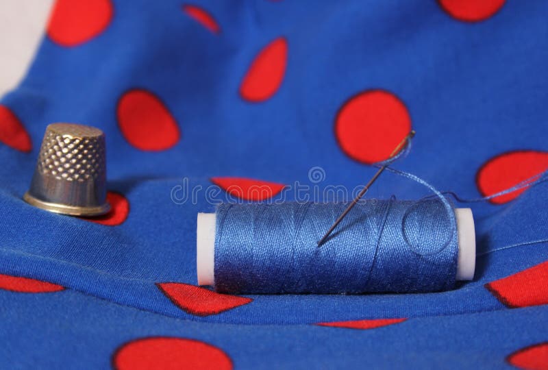Spool of Blue Thread on Vintage Blue and Red Dress Stock Image - Image ...