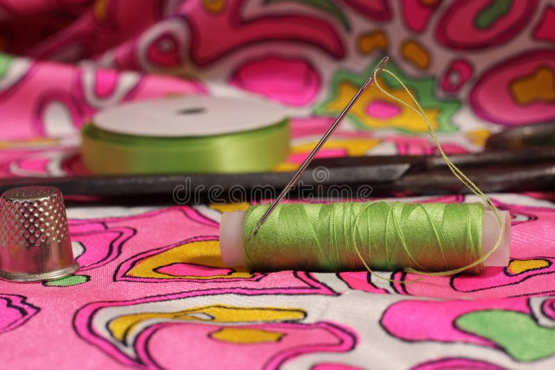Spool of Green Thread, Thimble and Needle on Retro Pink and Green ...