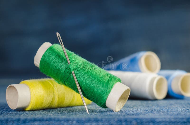 Spool of Green and Yellow Thread with a Needle on the Background of ...