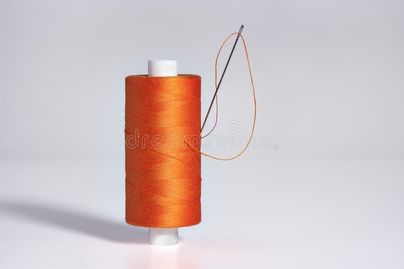 Spool of Orange Threads with a Needle on White Background Stock Photo ...