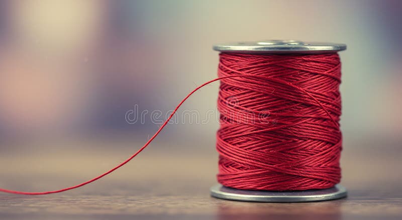 A Spool of Red Thread is Tightly Wound on a Metallic Bobbin. the ...