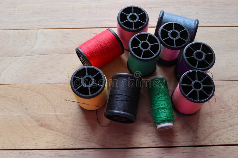 Spool of Thread Pile Multicolor and Sewing Needle Isolated on Wooden ...