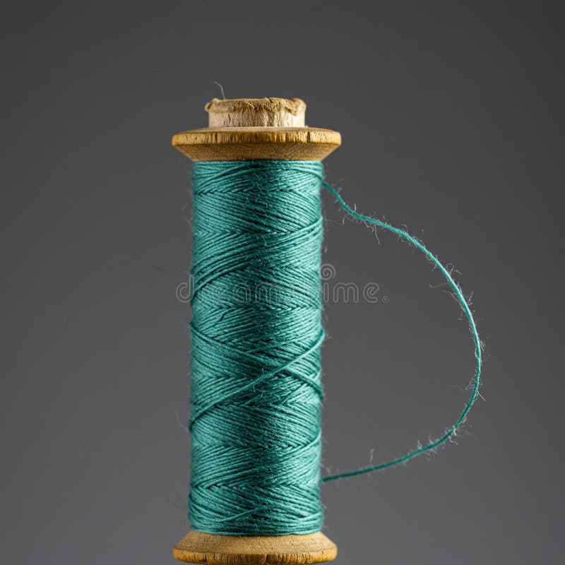 A Spool of Turquoise Thread is Wrapped Around a Wooden Bobbin. the ...