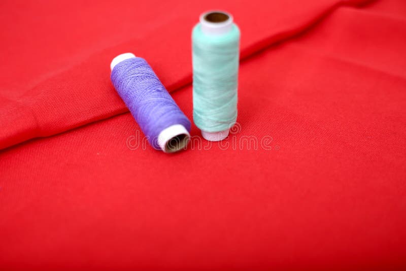 Spool of Two Sewing Thread on the Red Cloth Stock Photo - Image of ...