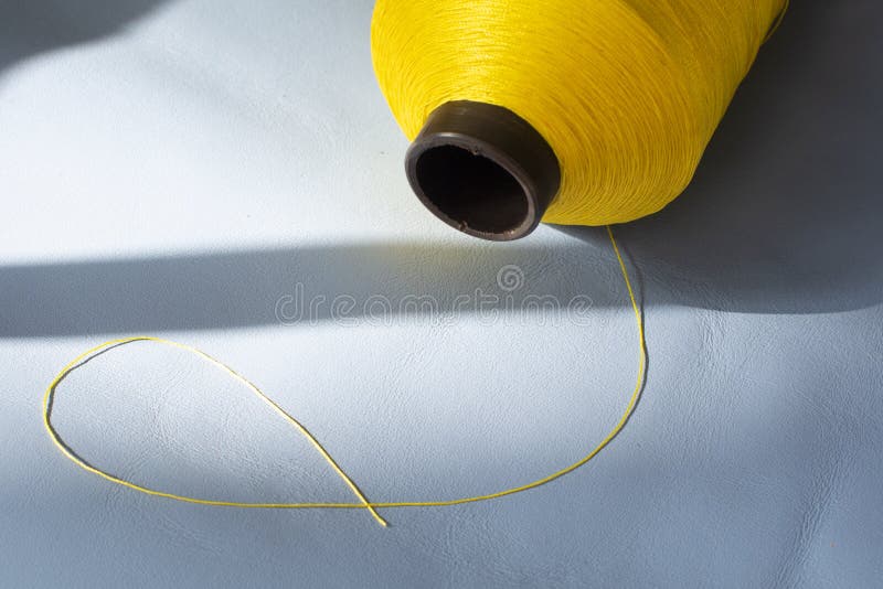 A Spool of Yellow Thread on a Blue Leather. Sewing Thread. Shoe ...