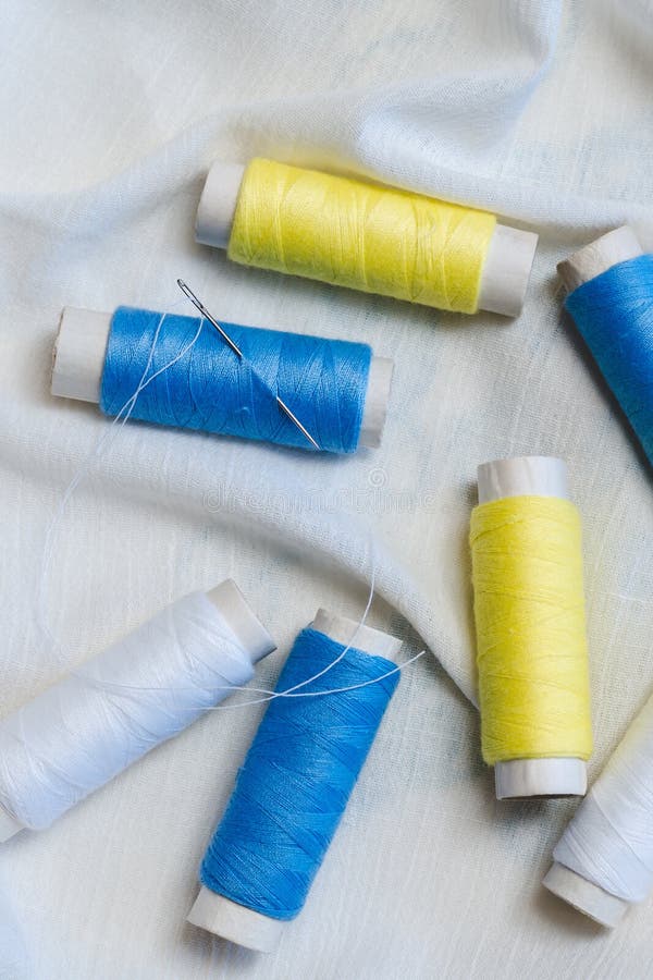 Spools of Blue, Yellow and White Threads and Sewing Needle on White ...