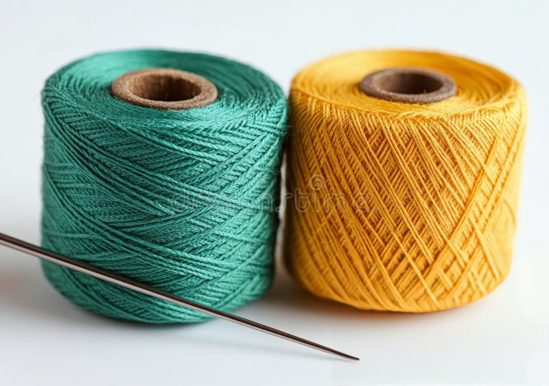 Spools of Green and Yellow Thread with a Sewing Needle on a Light ...