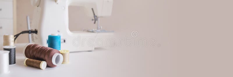 Spools of Multi-colored Thread on the Table Next To the Electric Sewing ...