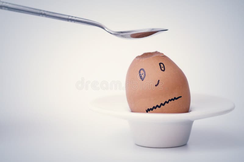 Spoon Breaks Sad Egg on a Stand in the Form of Human Head . Stock Image ...