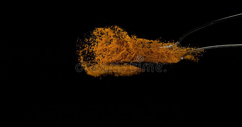 Spoon and Curry Powder Falling from Spoon Against Black Background ...