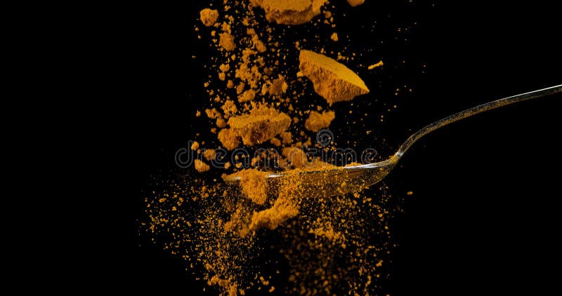Spoon and Curry Powder Falling from Spoon Against Black Background ...