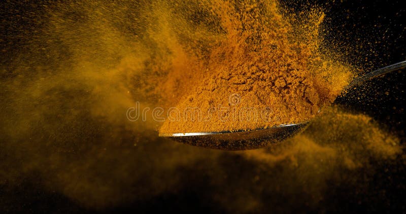 Spoon and Curry Powder Falling from Spoon Against Black Background ...