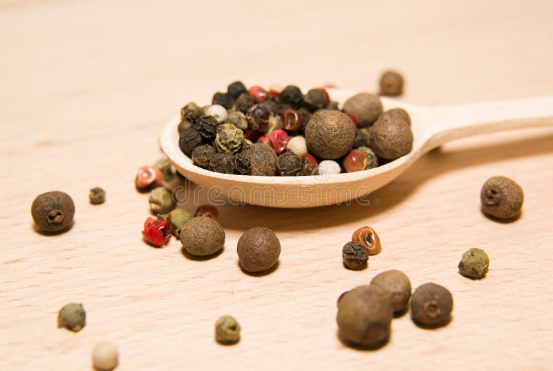 Spoon Filled with a Mixture of Grains of Pepper are on a Wooden Stock ...