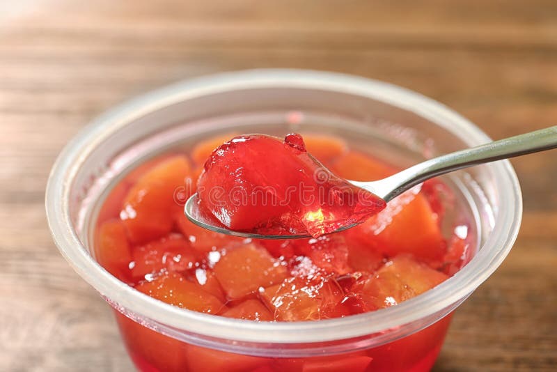 Spoon with Fruit Jelly Over Plastic Container on Table Stock Image ...