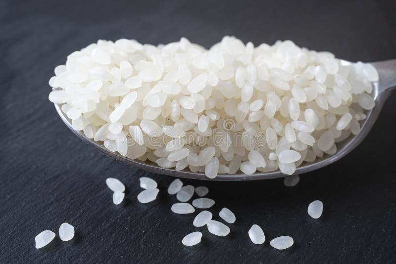 Spoon Full of White Rice Isolated on a Black Stone Tile Stock Photo ...