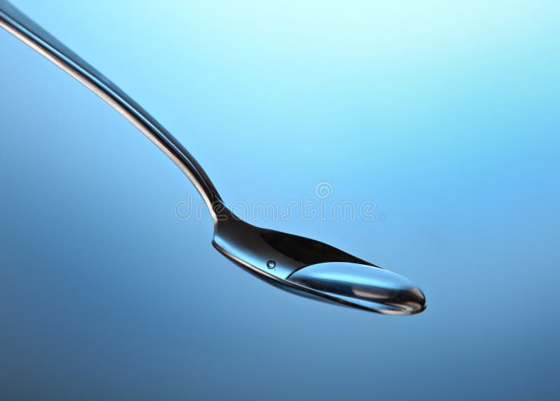 A Spoon with Liquid Gel Pills on a Blue Background Stock Image - Image ...