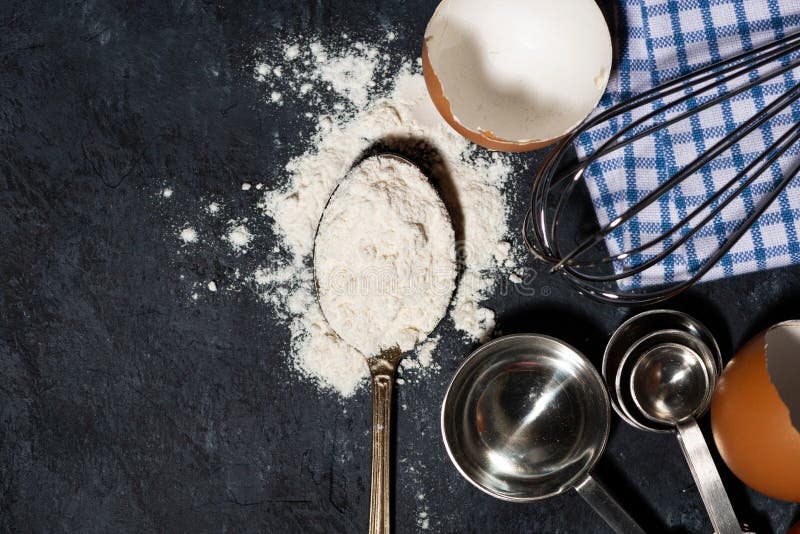 Spoon with Wheat Flour and Baking Ingredients on a Black Background ...