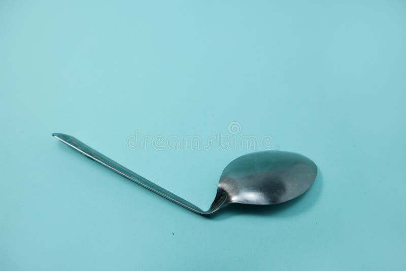 A Used and Bent Spoon, Isolated on a Blue Background. Stock Photo ...
