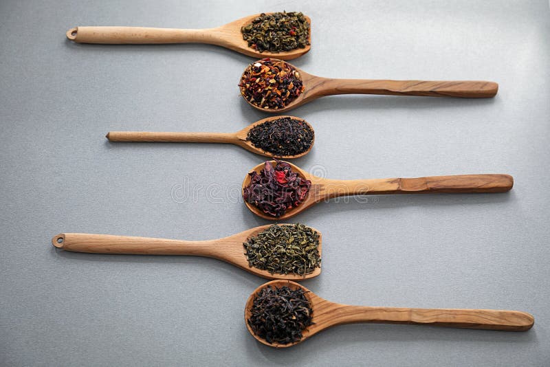 Spoons with Different Types of Dry Tea Leaves on Grey Background Stock ...