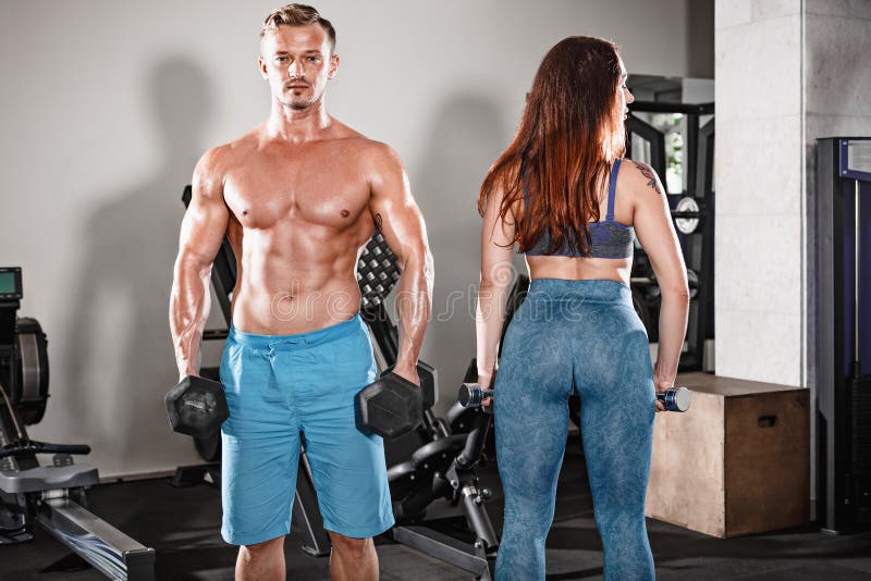 Sport Fit Couple at Gym. Work in Pairs with Dumbbells Stock Image ...