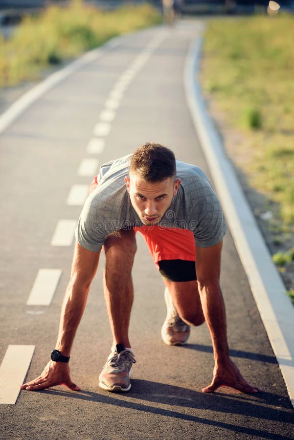 Sports Man Runner with Smart Watch in Start Position Preparing To Run ... Sports Man Runner with Smart Watch in Start Position Preparing To Run ...