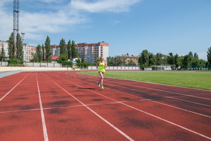 Woman runs in the stadium stock photo. Image of athlete - 252901476