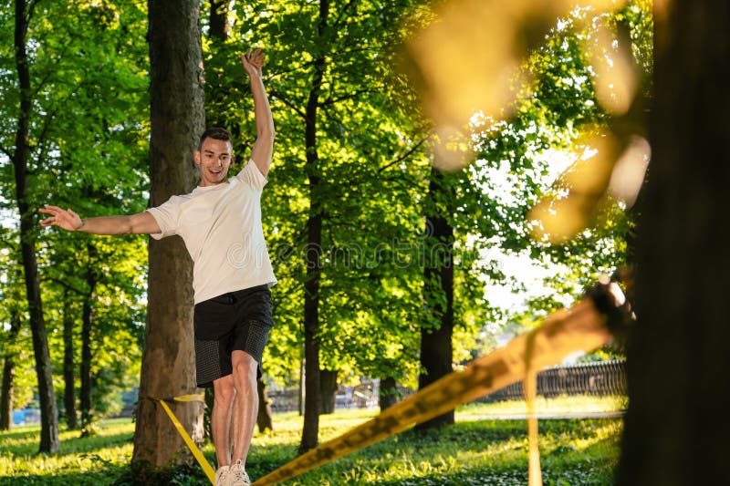 Sportsman on the Rope Practising Slacklining and Looking Concentrated ...