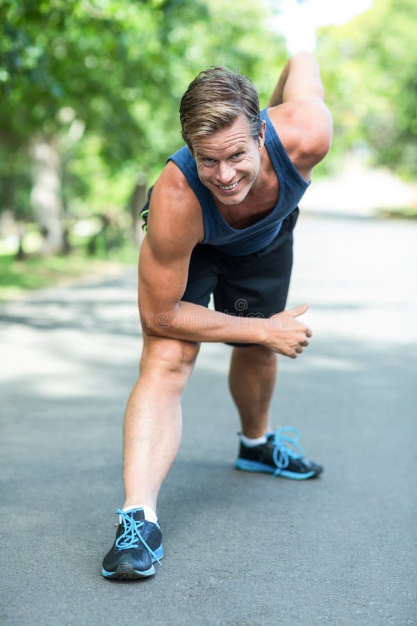 Sportsman Stretching His Legs Stock Photo - Image of male, sunlight ...