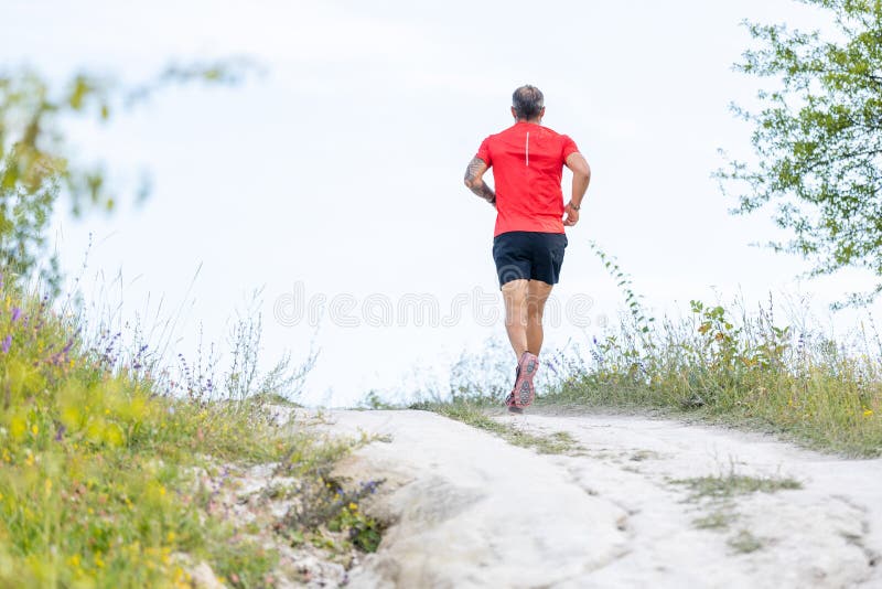 Sporty Bearded Man Running on the Path at Hillside Stock Photo - Image ...