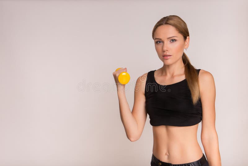 Sporty Girl Doing Exercise With Dumbbells And Looking At Camera Stock