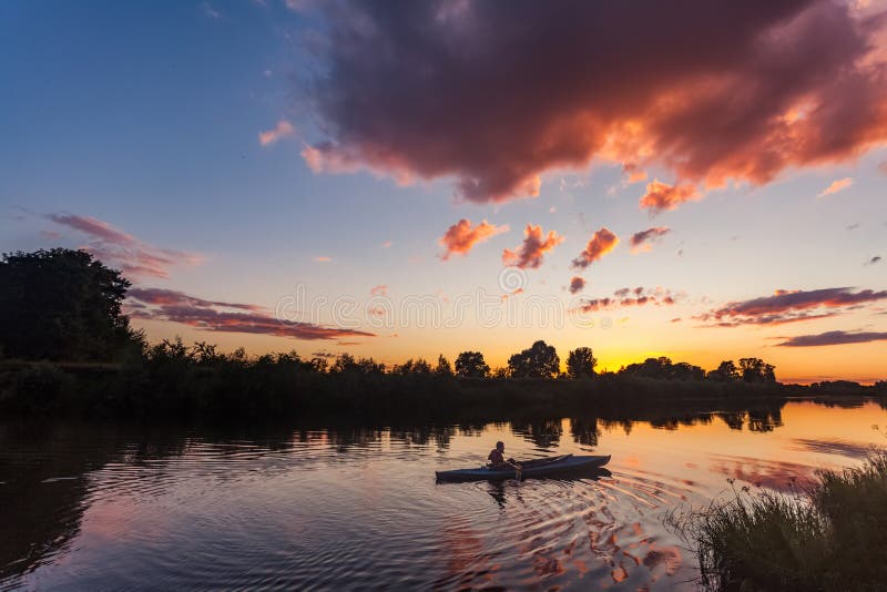 Sporty Man Kayaking on River Surrounded by Forest at Sunset Stock Photo ...