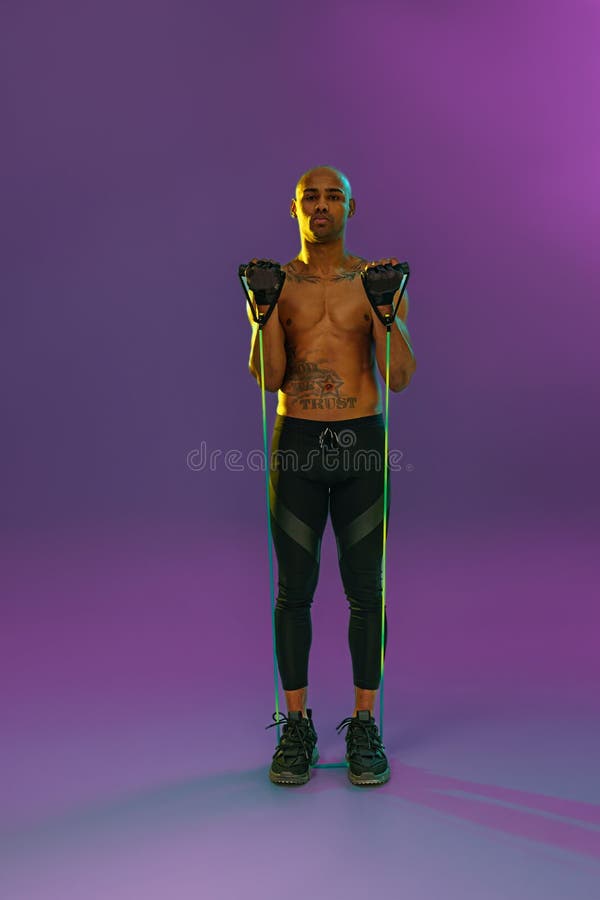 Sporty Man Performs Exercises with Expander on Studio Background ...