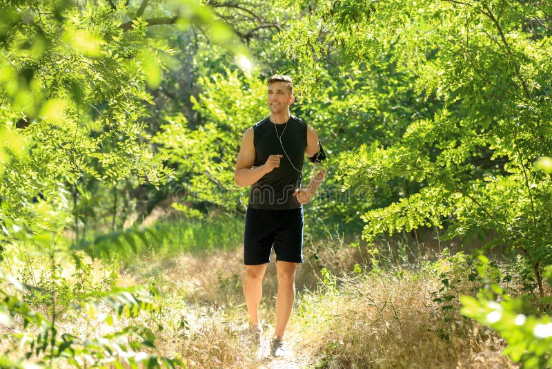 Sporty man running in park stock image. Image of listening - 151120021