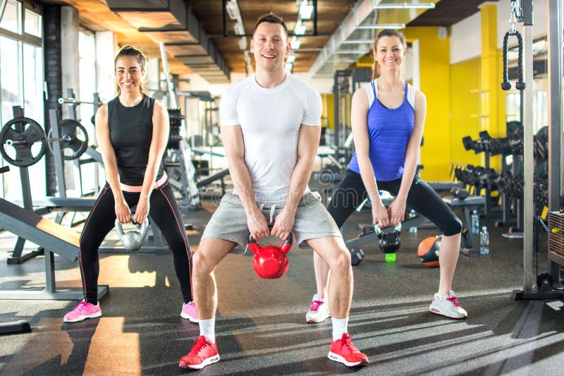 Sporty People Working Out with Kettle Bells in Gym. Stock Image - Image ...