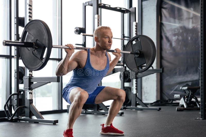 Sporty Strong Man Lifting Barbell in Gym. Stock Photo - Image of ...