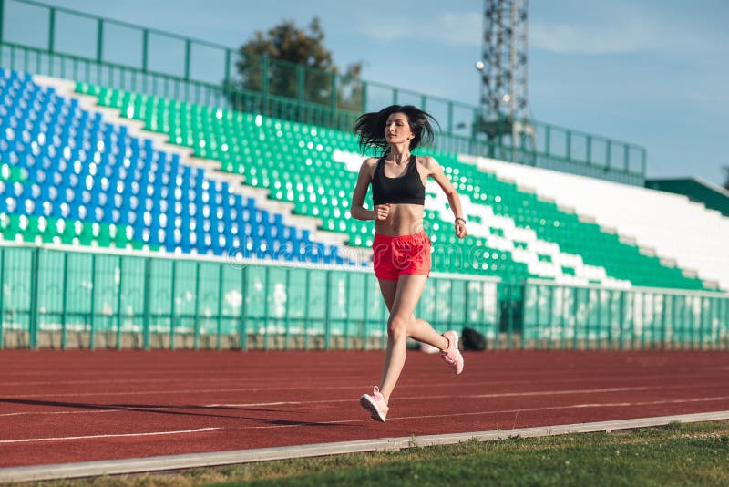 Sporty Young Brunette Woman In Pink Shorts And Tank Top Running At The